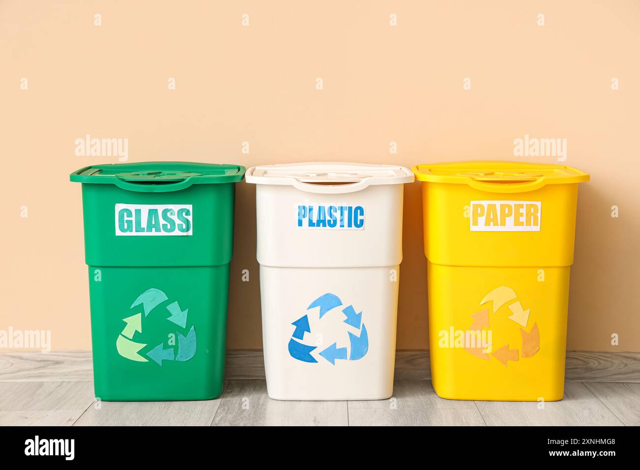 Empty trash bins for different types of garbage near beige wall ...