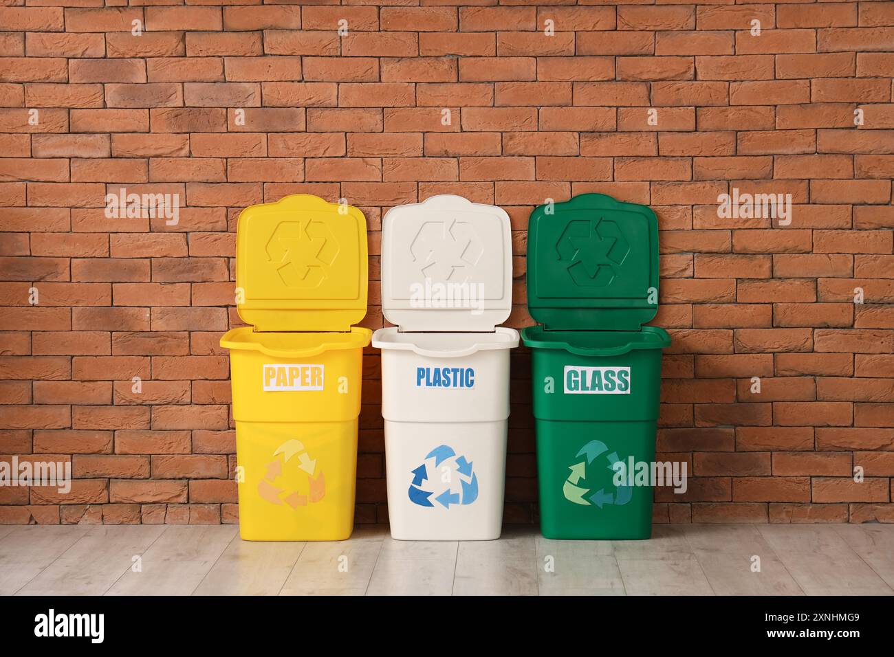Empty trash bins for different types of garbage near brick wall ...