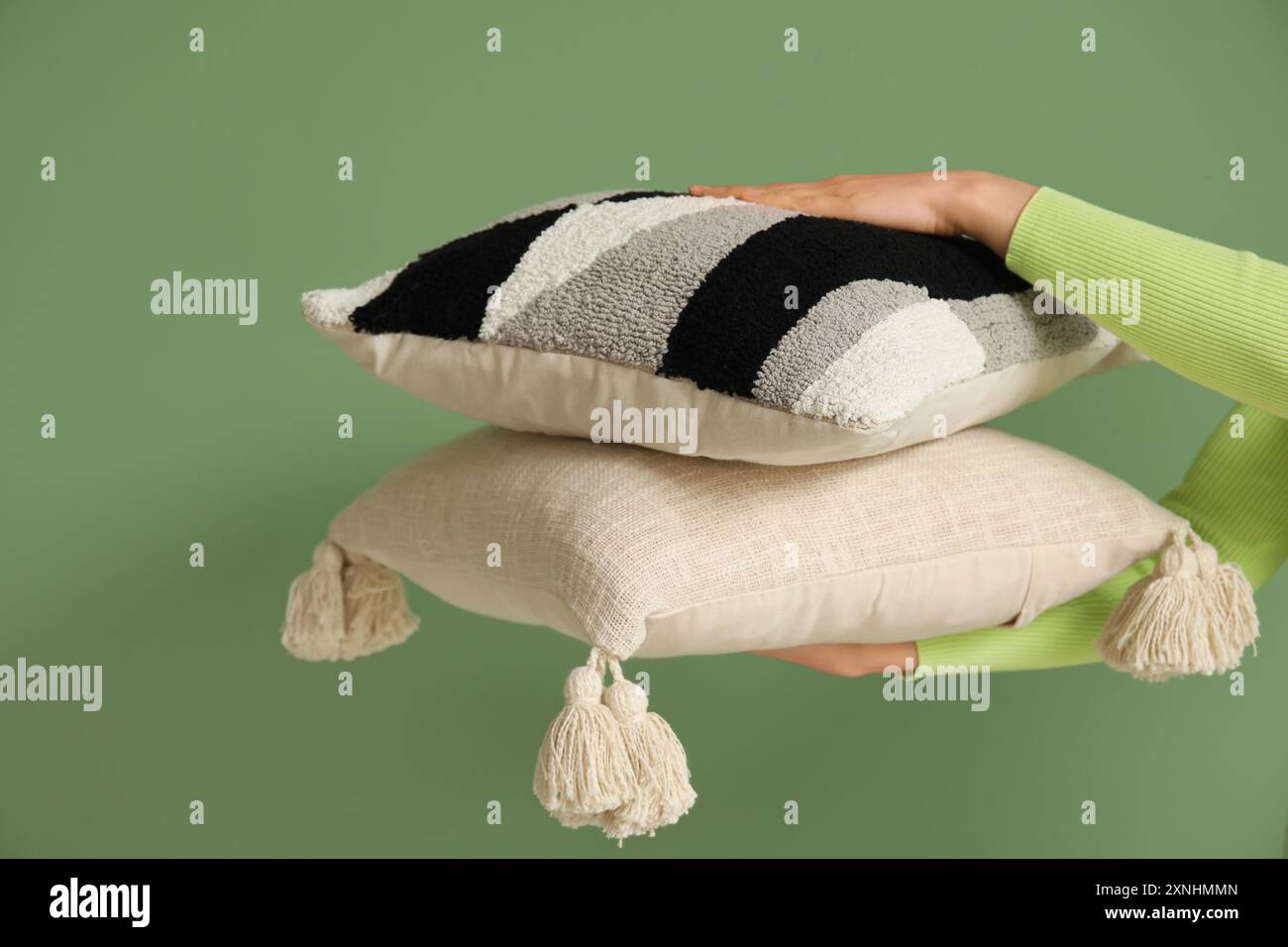 Female hands with pillows on green background Stock Photo - Alamy