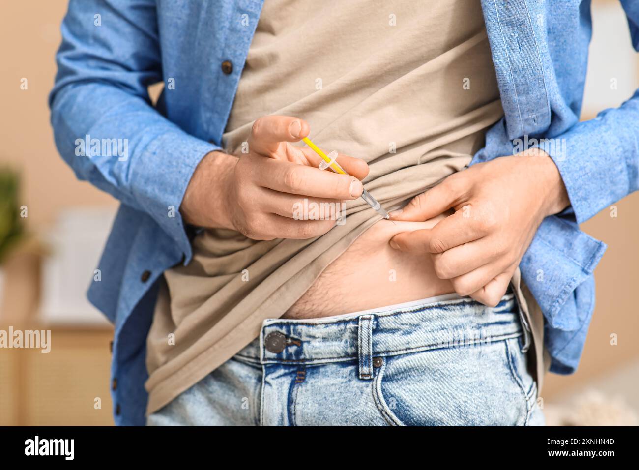 Diabetic young man giving himself insulin injection at home, closeup ...