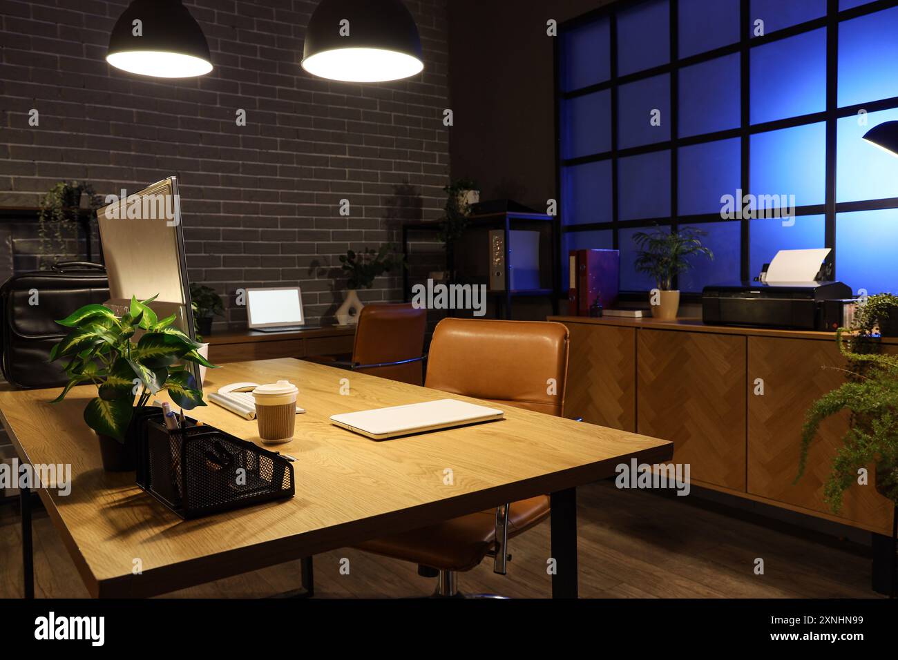 Interior of dark office with workplace, plants and glowing lamps Stock ...