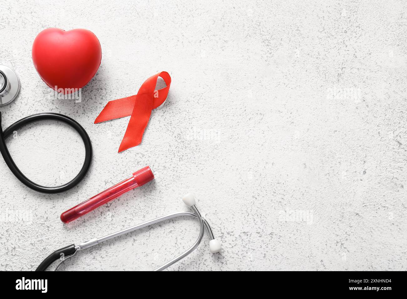 Red ribbon with stethoscope, blood sample and heart on grunge white ...