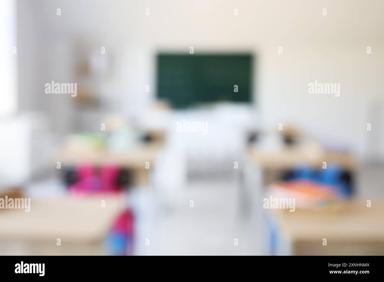 Blurred view of empty classroom with desks and blackboard Stock Photo ...