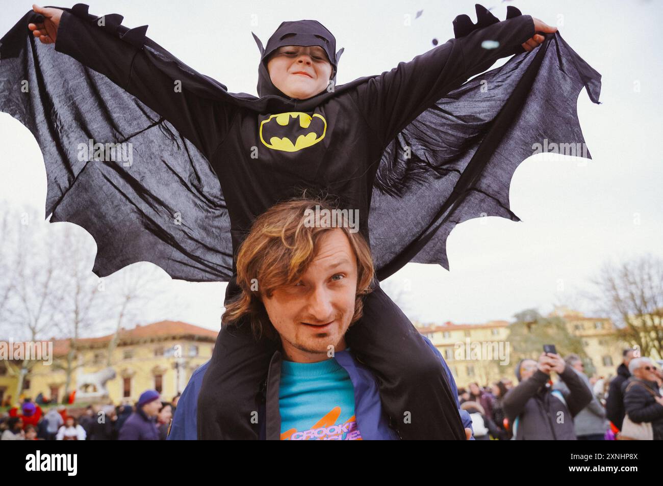Halloween. Little boy dressed as Batman sits on his dad's neck ...