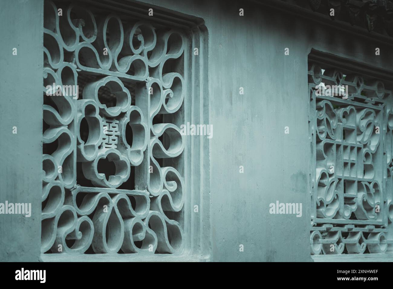 Ornate, white plaster lattice work on a wall with a muted green patina ...