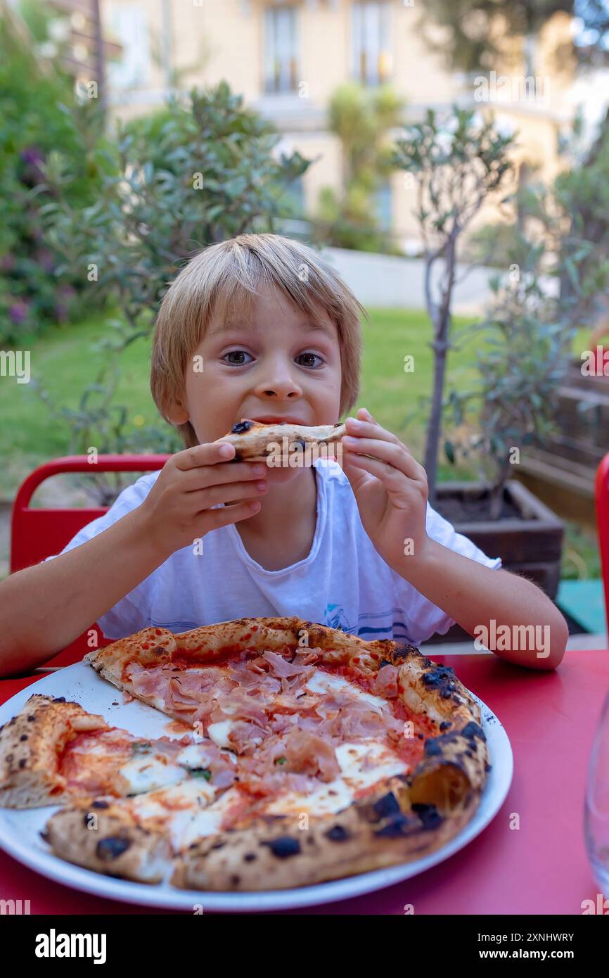 Child, eating pizza and burger in restaurant, summertime, good food ...