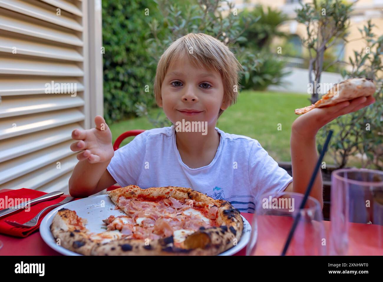 Child, eating pizza and burger in restaurant, summertime, good food ...