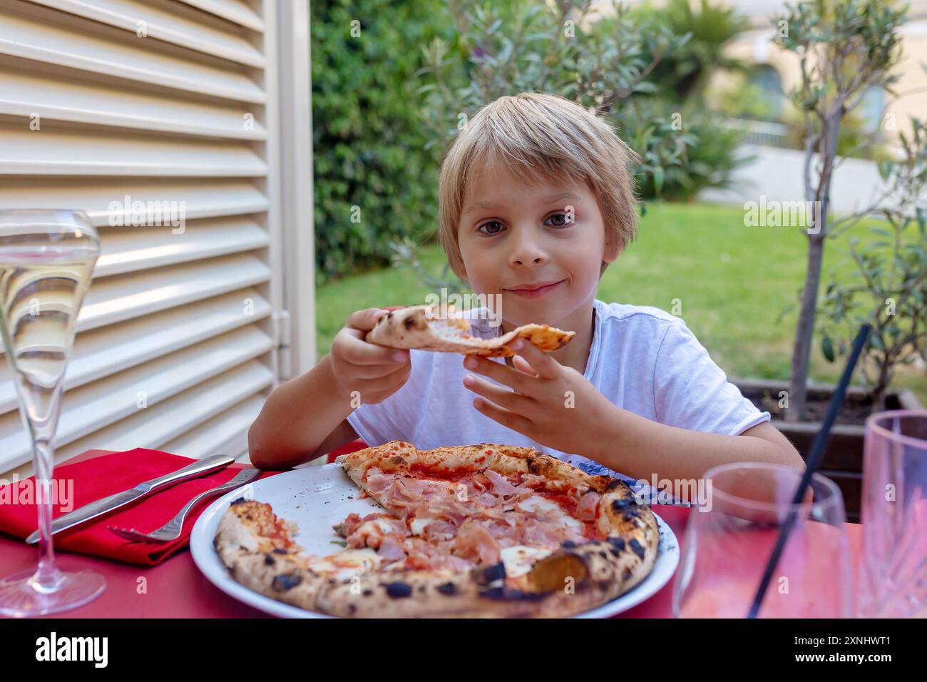 Boy eating pizza outdoors hi-res stock photography and images - Alamy