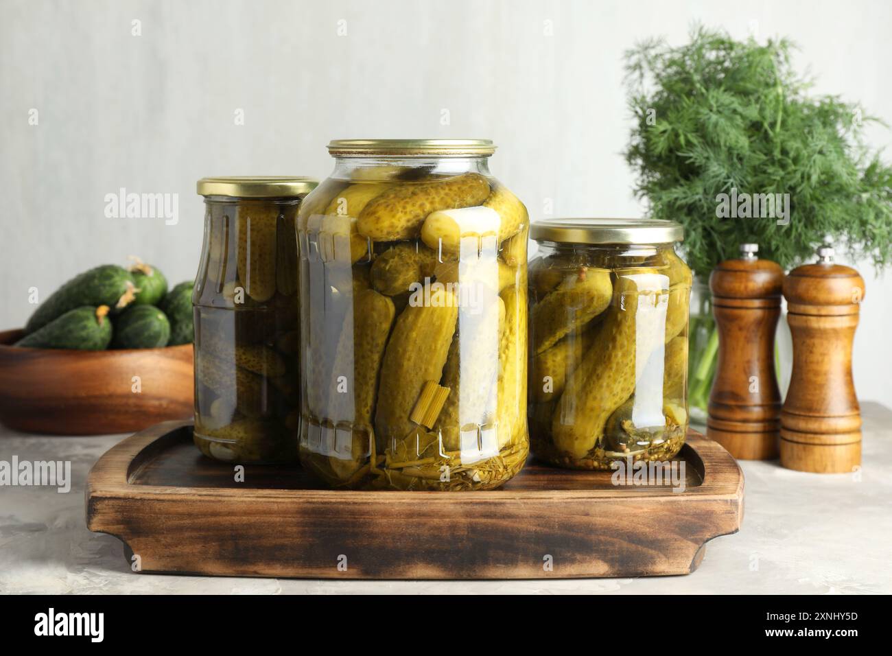 Pickled cucumbers in jars on grey table Stock Photo - Alamy