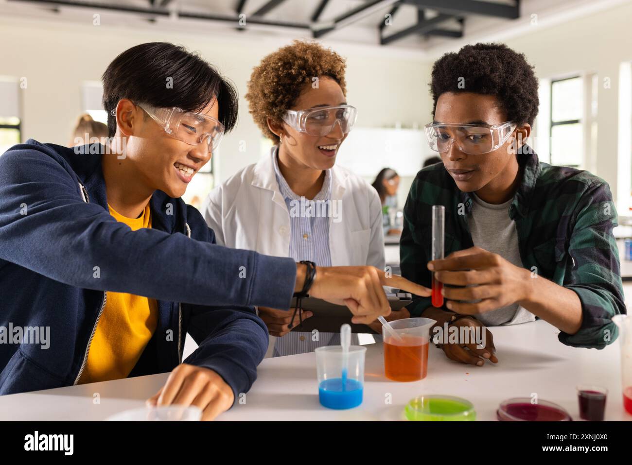 In high school, teenagers conducting science experiment with test tubes ...