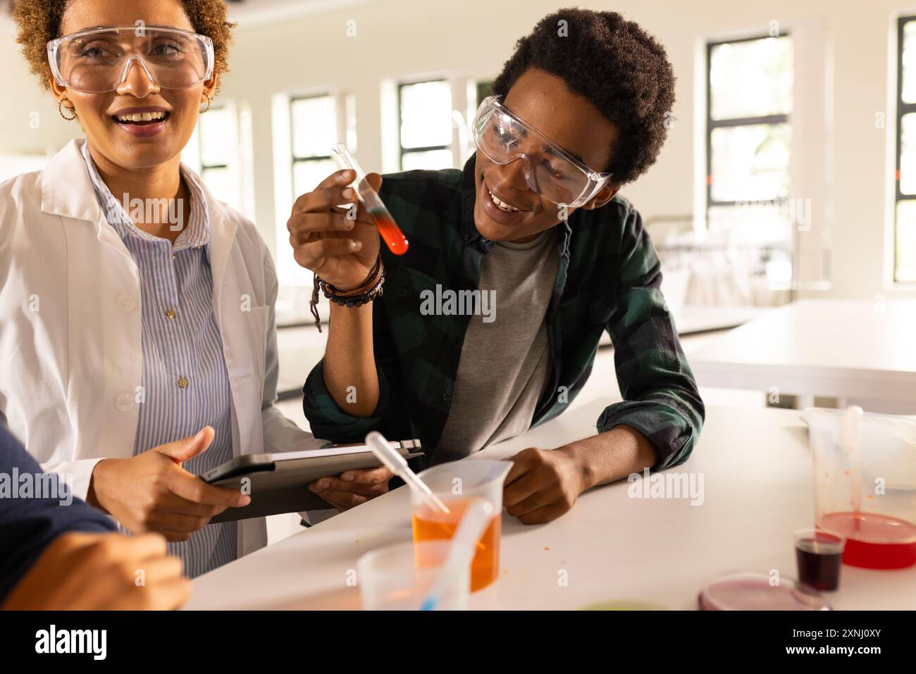 In high school, students conducting science experiment with test tubes ...