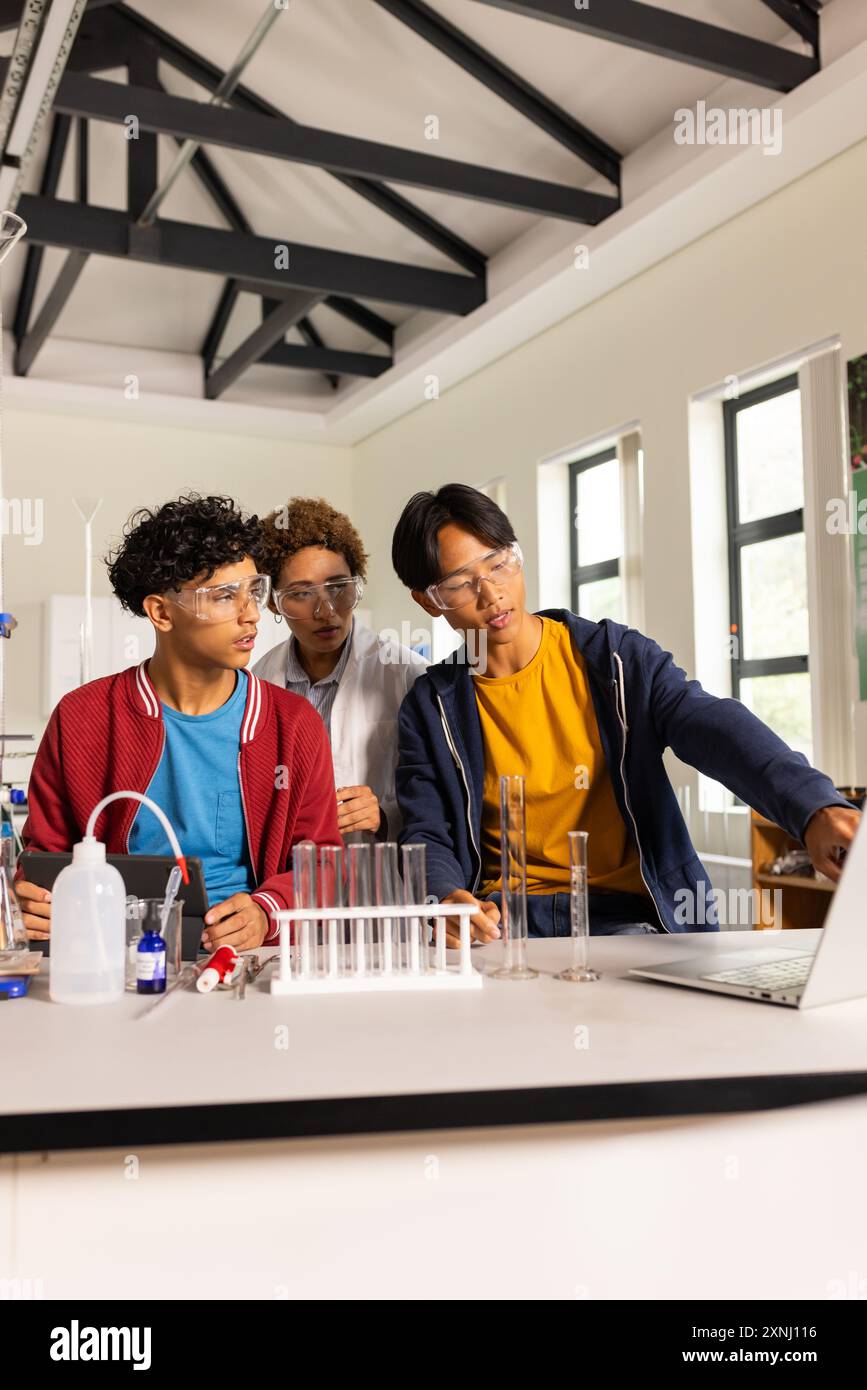 Conducting experiment and analyzing results on laptop, teenagers in ...