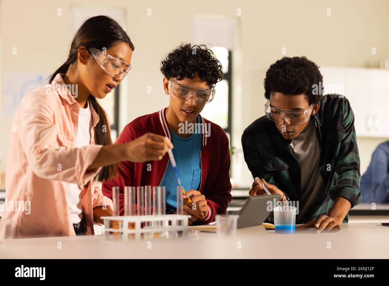 Conducting Science Experiment With Test Tubes And Safety Goggles Teenagers In High School Stock