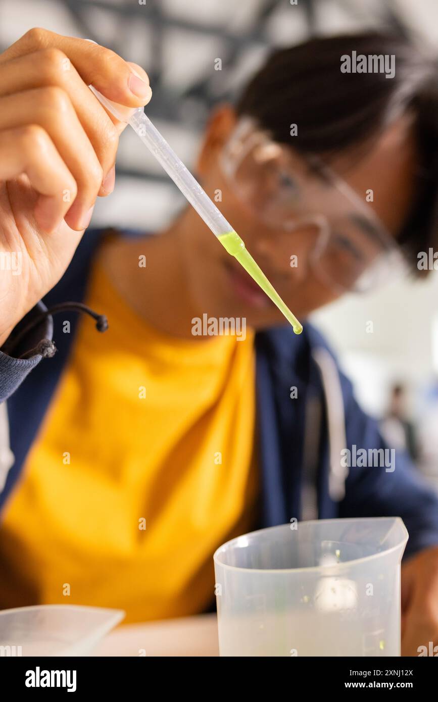 In high school, teenager using pipette for science experiment in ...