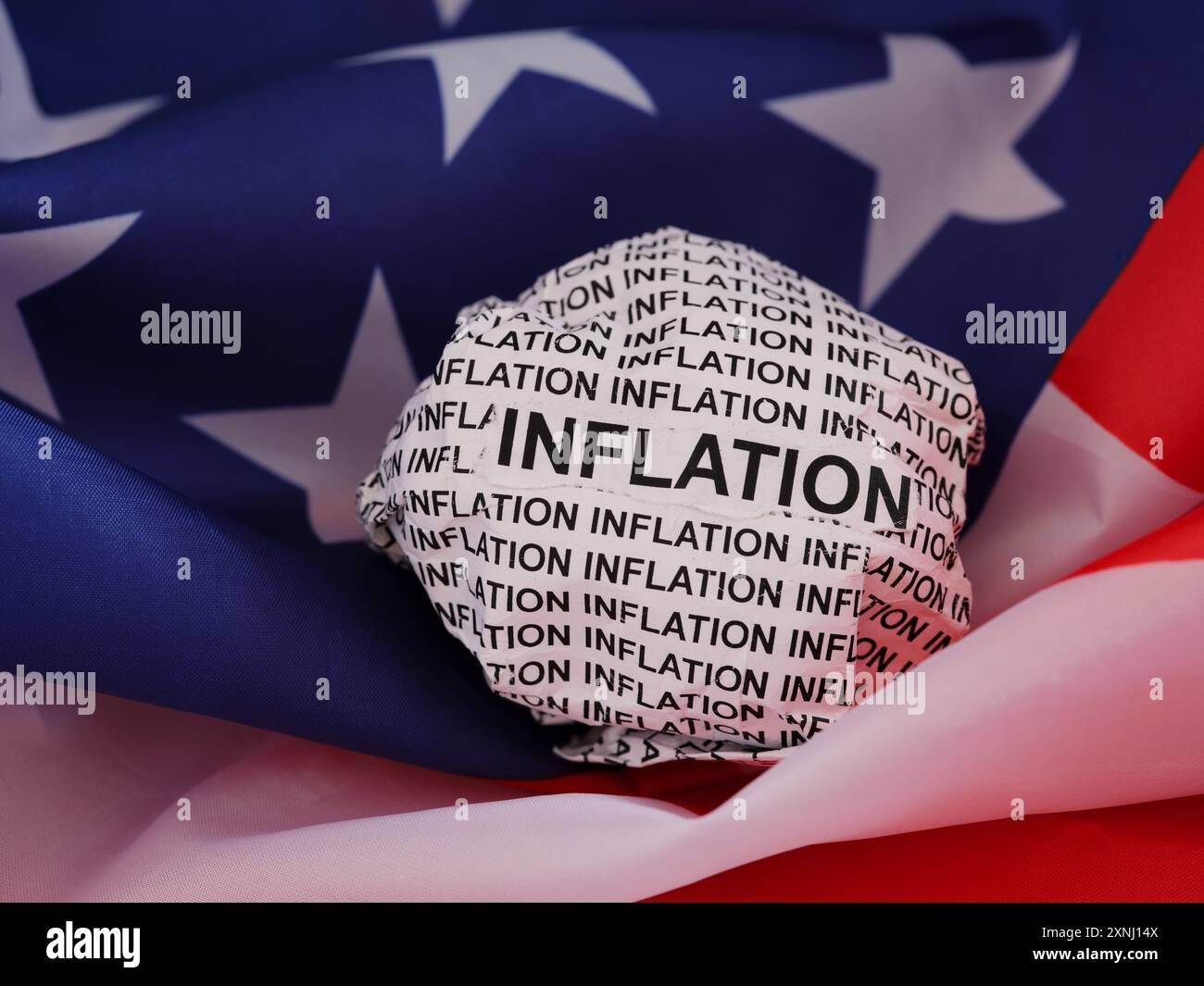 Crumpled paper ball with words Inflation lying on an American flag ...