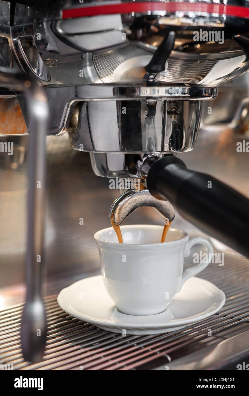 Professional espresso machine pouring coffee in a white cup standing on ...
