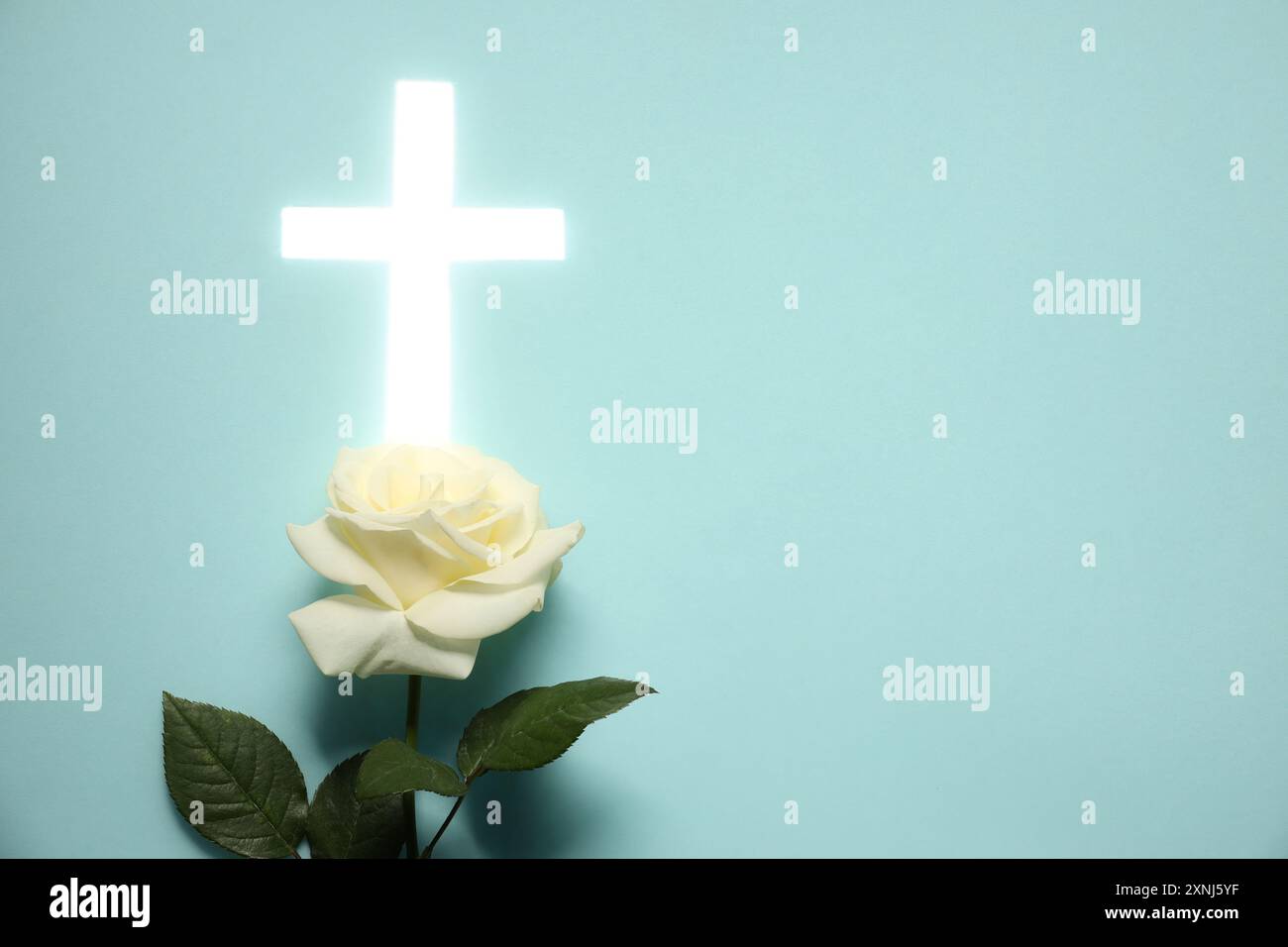 Shining cross and rose flower on turquoise background. Religion of ...