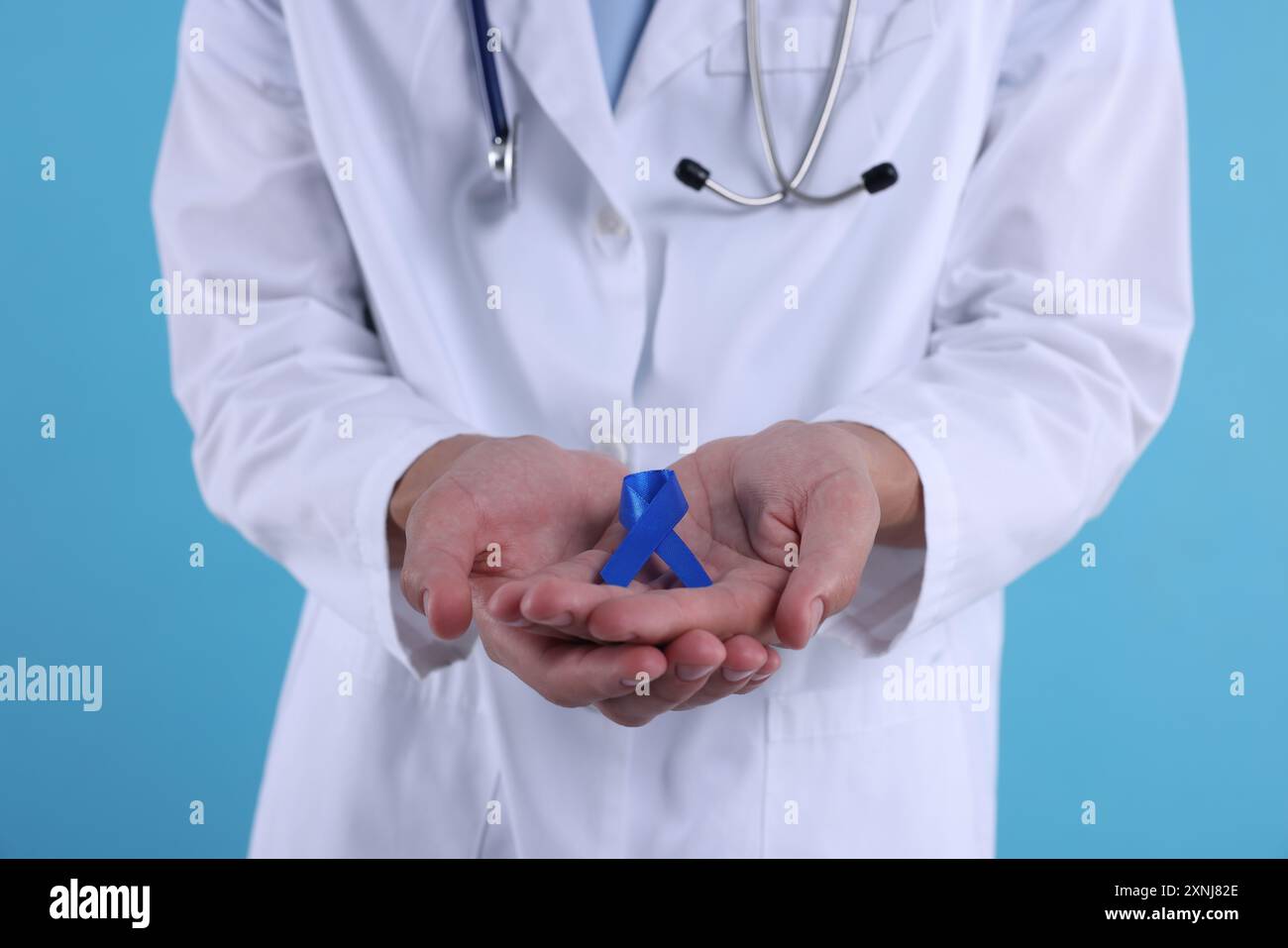Prostate cancer awareness. Doctor holding blue ribbon as symbol of ...