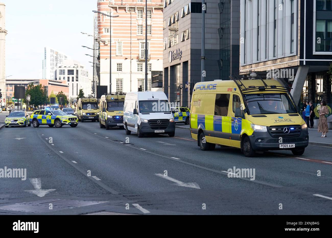 A prison van escorted by multiple police vehicles arrives at Liverpool ...