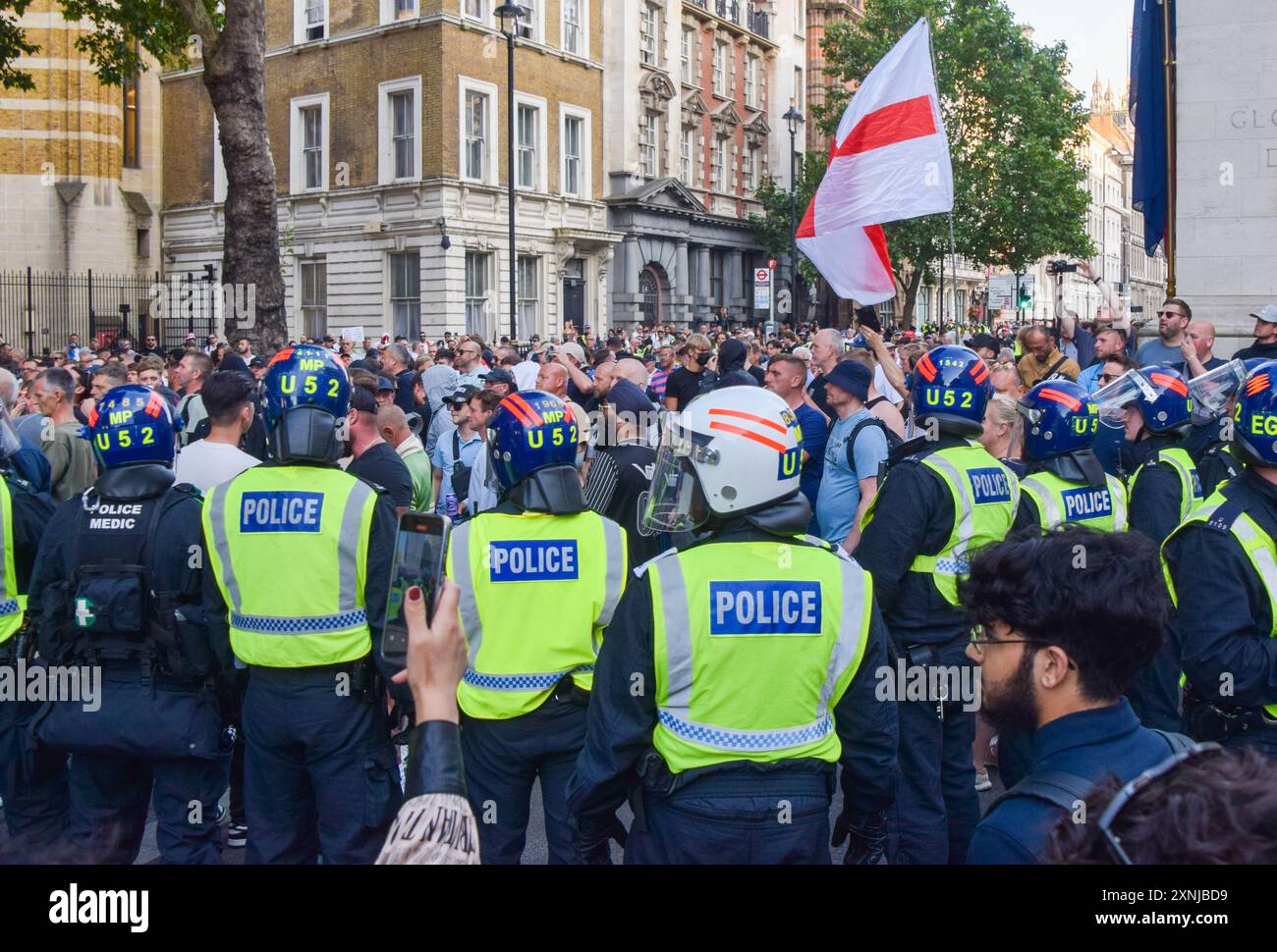 London, UK. 31st July 2024. Police in riot gear face off with ...