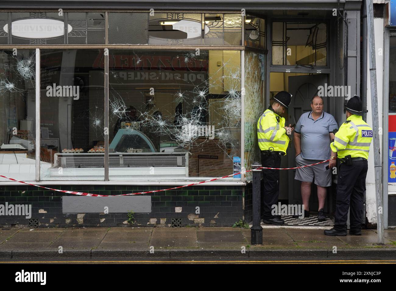 Police officers outside a damaged butchers shop on Murray Street in ...