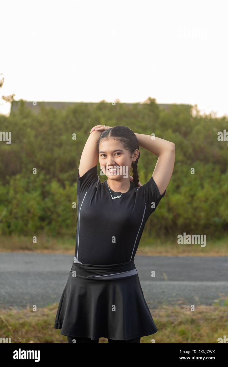 portrait Beautiful Asian sports girl in black clothes standing ...