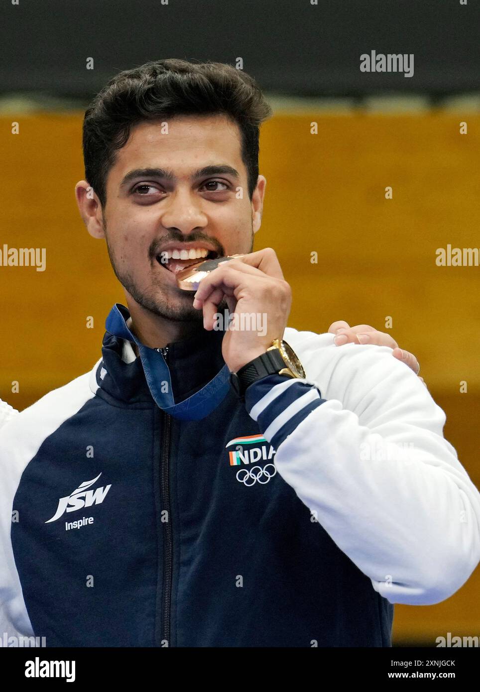 India's Swapnil Kusale bites his bronze medal winning it in the 50m ...