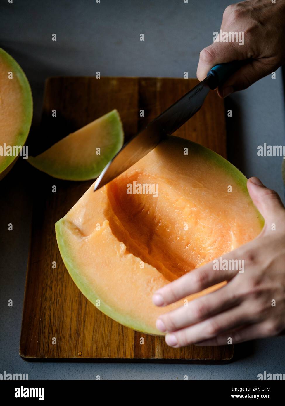 cutting a melon with a knife Stock Photo - Alamy
