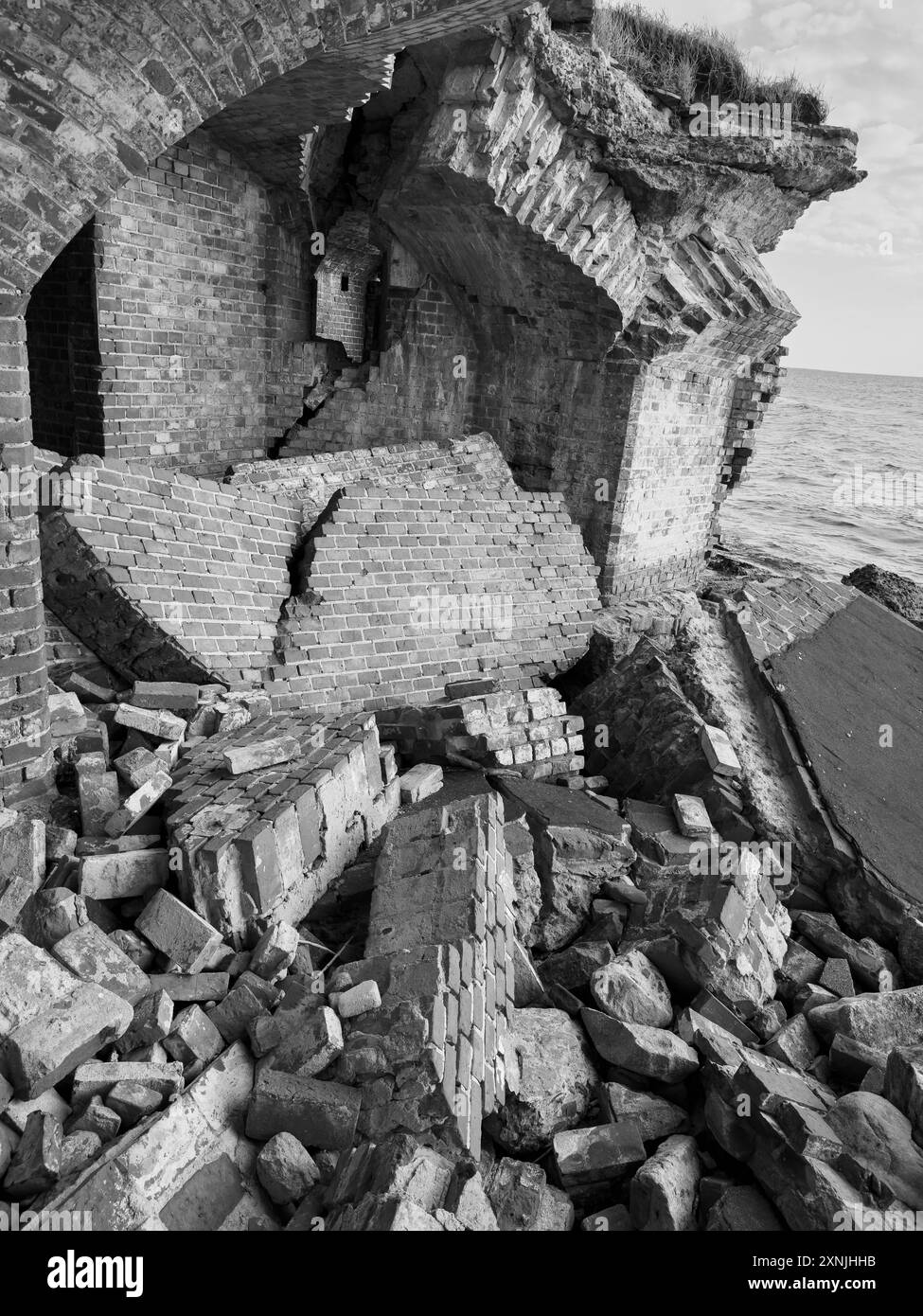 Black and white photo of crumbling brick ruins by the sea. Highlights ...