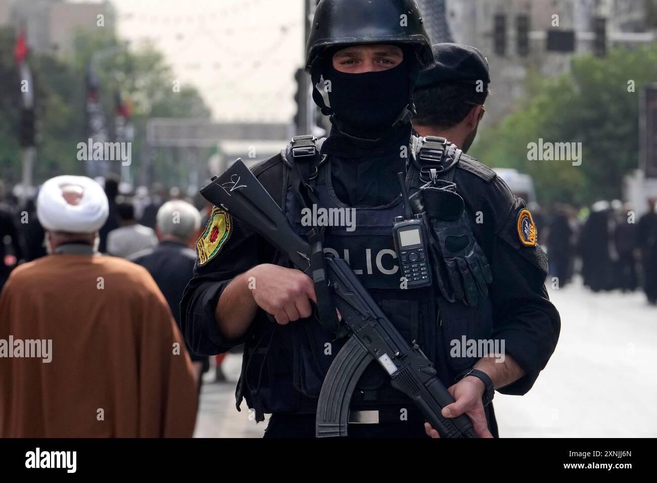 An Iranian police officer stands guard during the funeral ceremony of ...