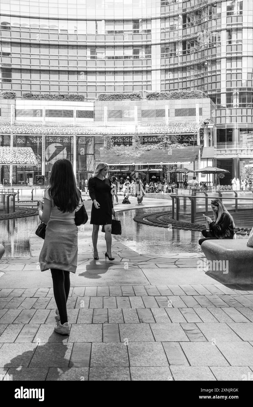 B&W. Girls in Piazza Gae Aulenti, a modern square crowned with arched ...