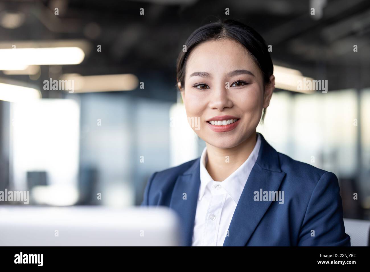 Confident businesswoman smiling in modern office. Professional attire ...