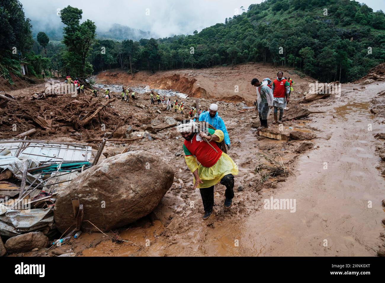 Rescuers make their way to the upper regions as they search through mud ...