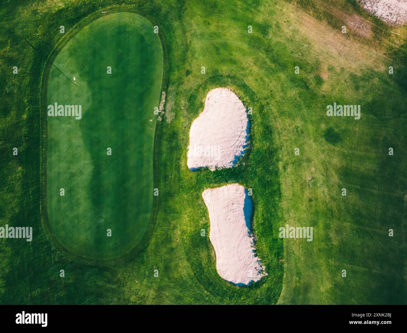 The green of a golf course is prominently displayed from above ...