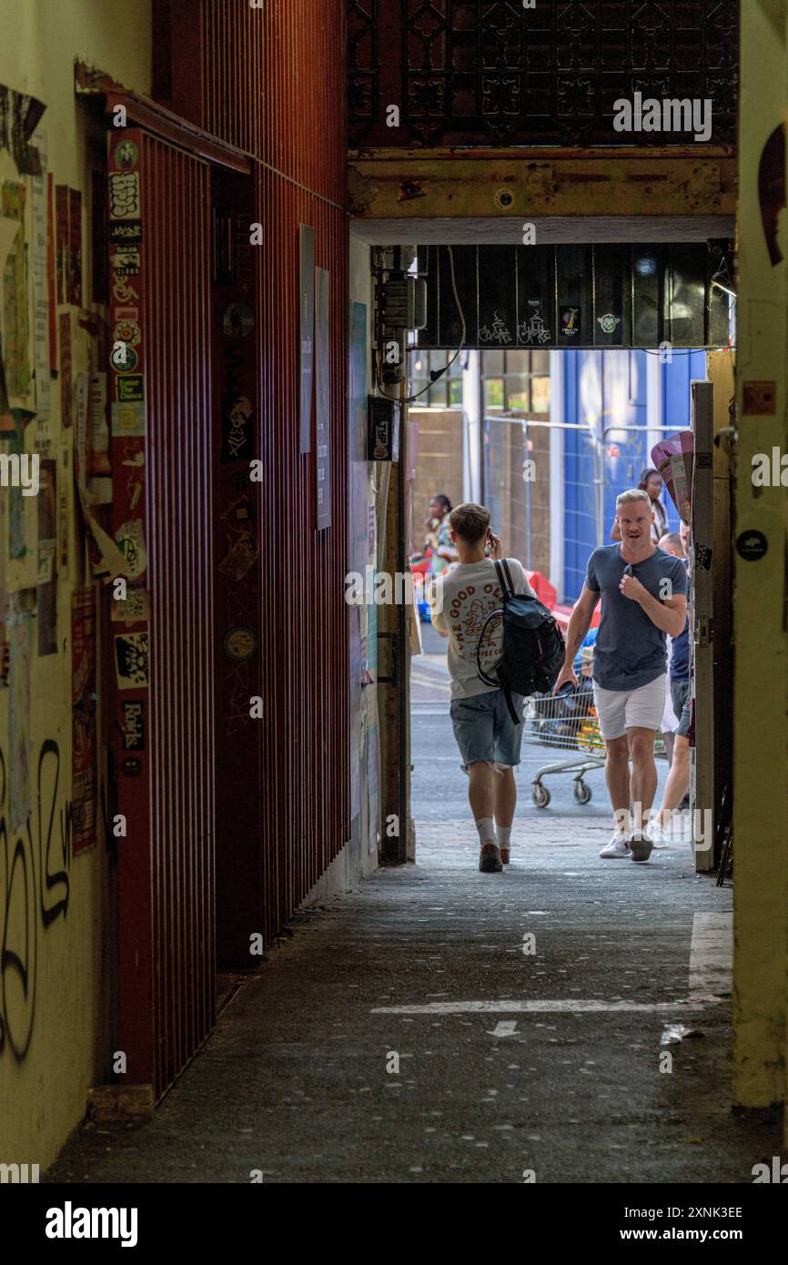 People walk along Bussey Alley leading to Rye Lane from Copeland Park ...
