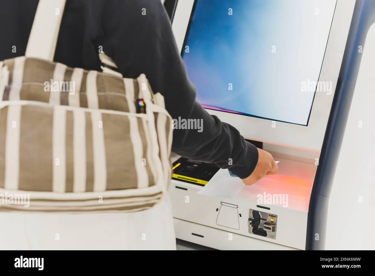 Woman passenger doing self check in scanning boarding pass at airport ...