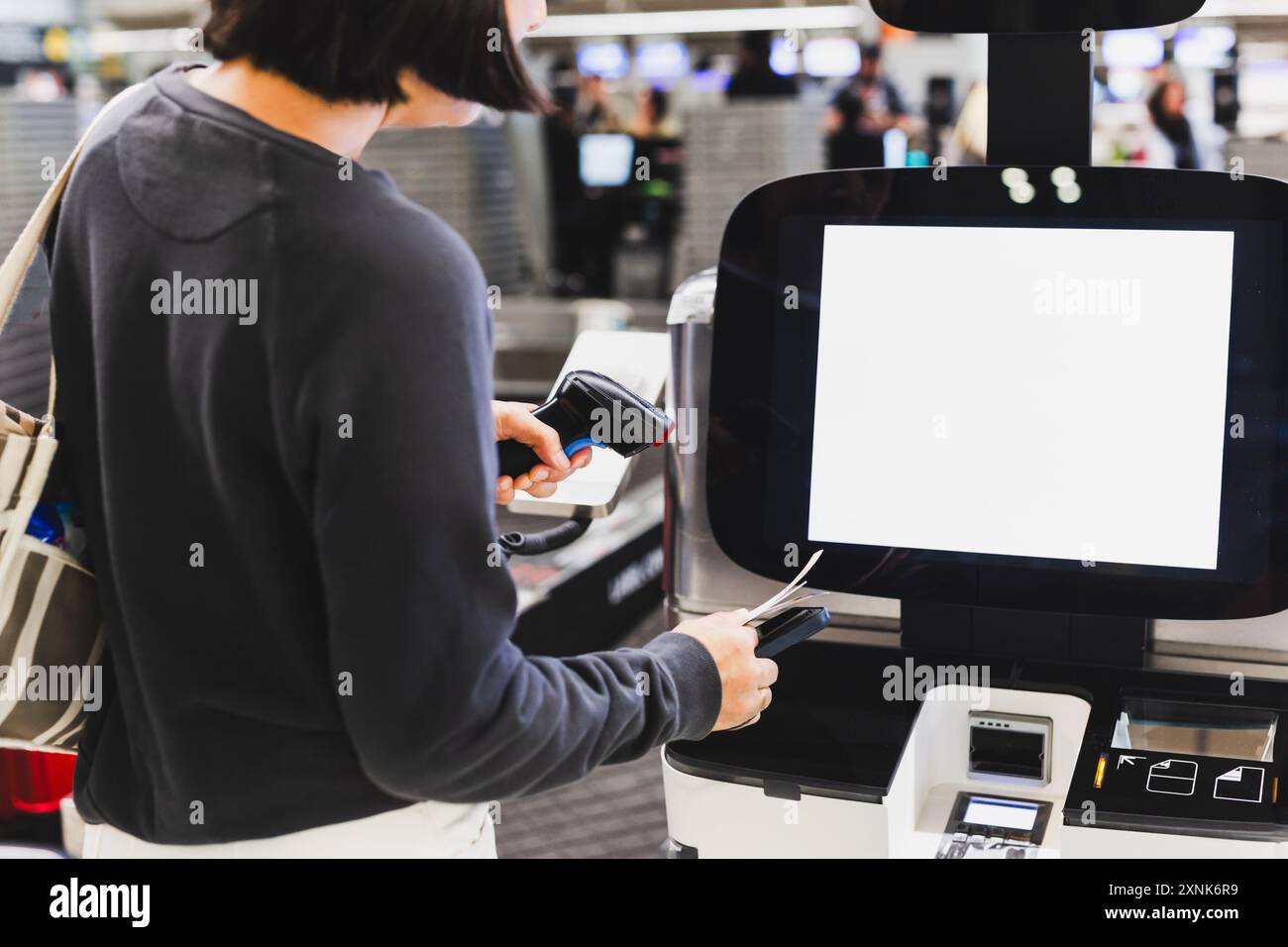 Woman passenger self check in scanning qr code boarding pass at airport ...