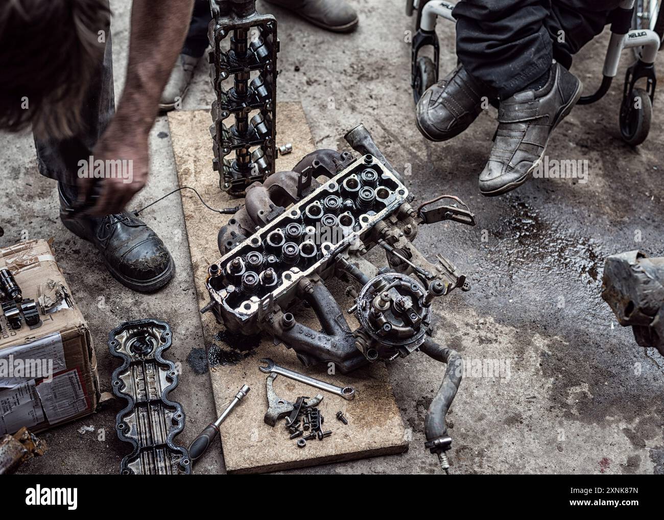 Mechanics meticulously tinkering with a disassembled car engine in a ...