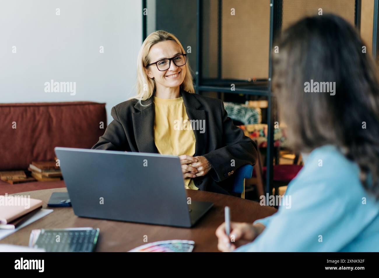 Portrait of a smiling beautiful business woman in glasses and a jacket ...