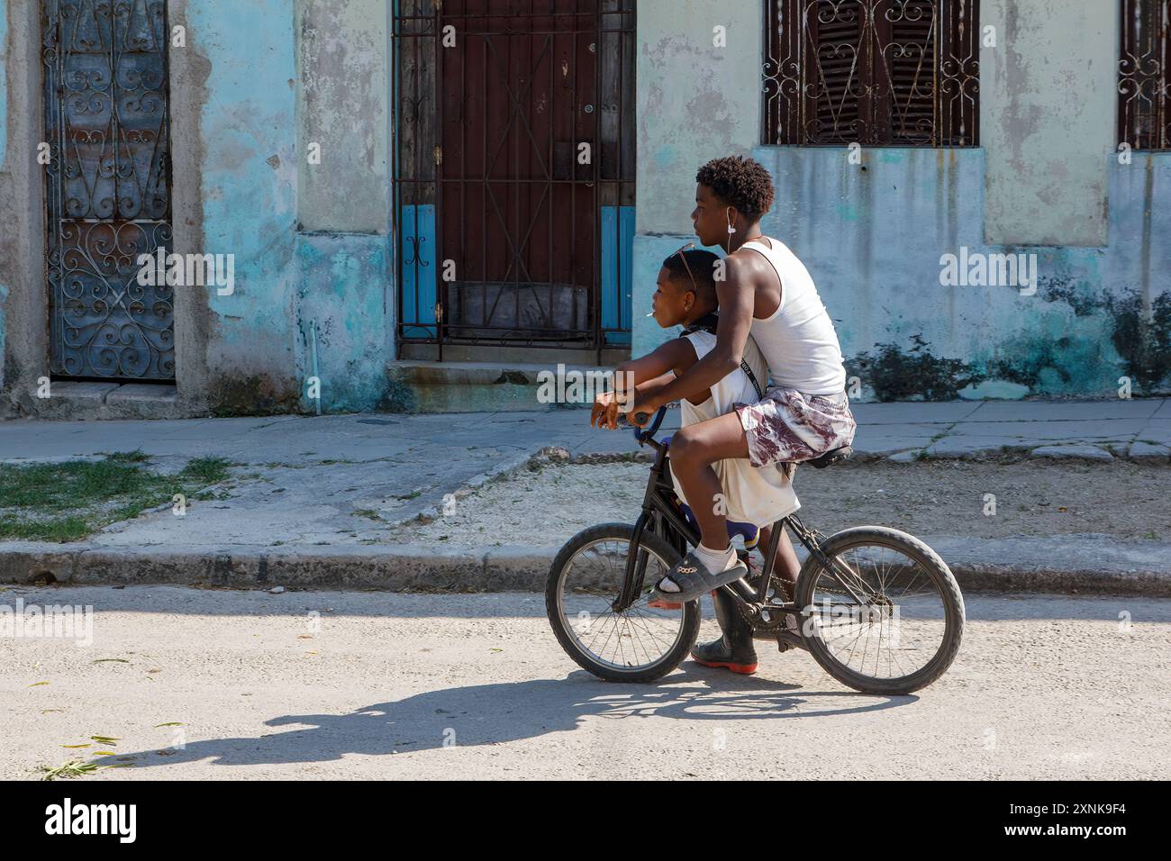 Two Cuban children riding a small bicycle Stock Photo - Alamy