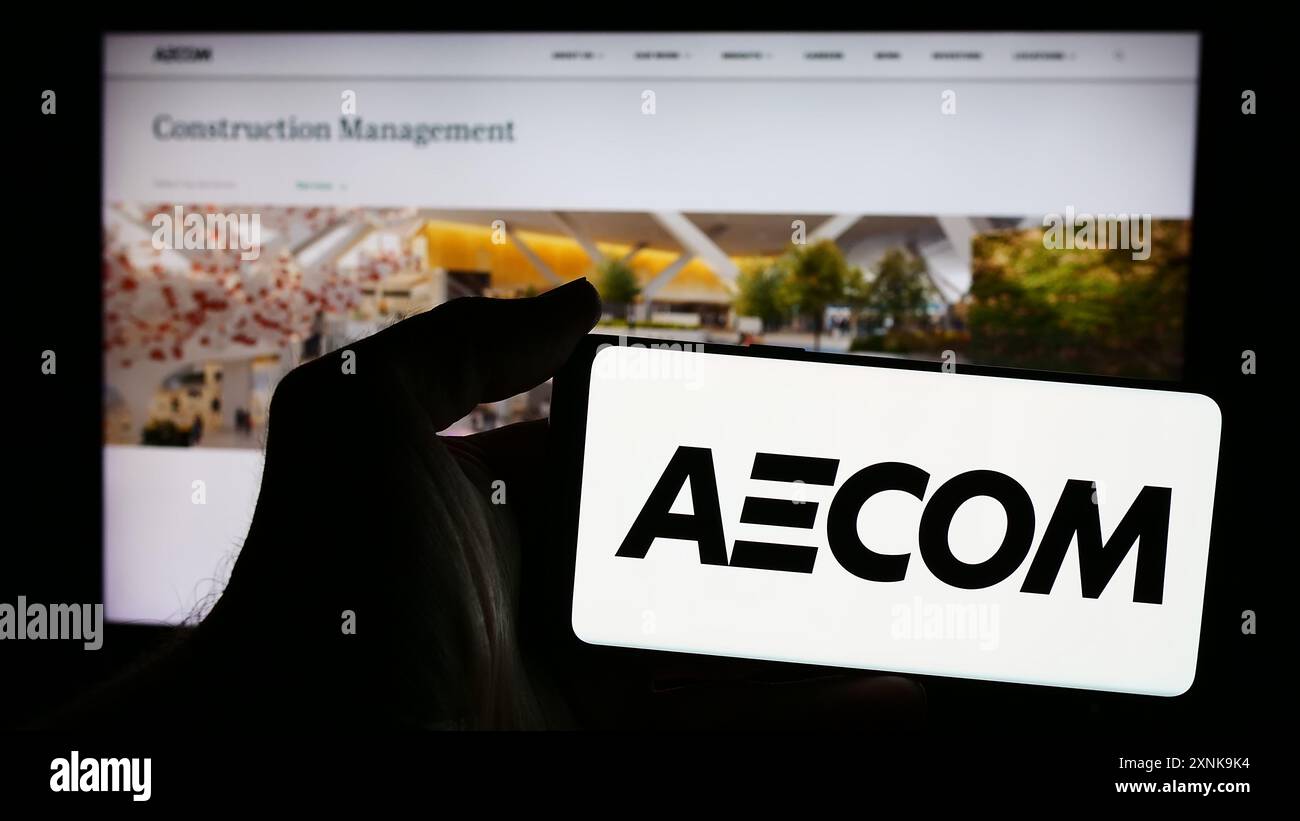 Person holding mobile phone with logo of American infrastructure ...