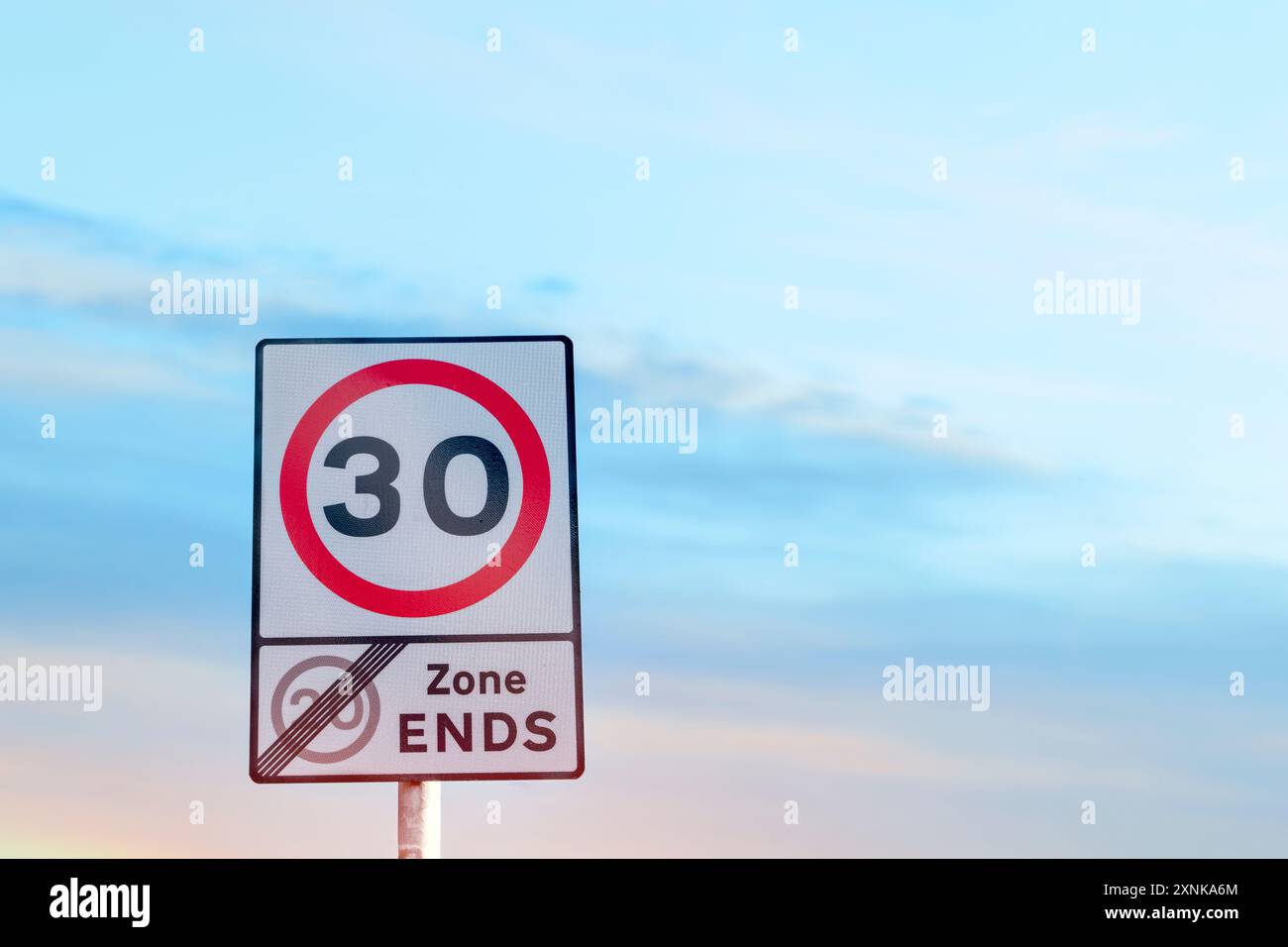 UK Road 30 mile an hour speed limit ahead road against the blue sky ...