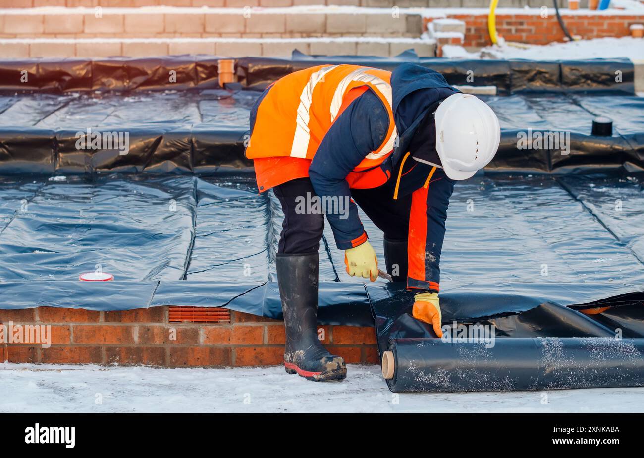 Waterproof installation at new house construction. Builders installing ...