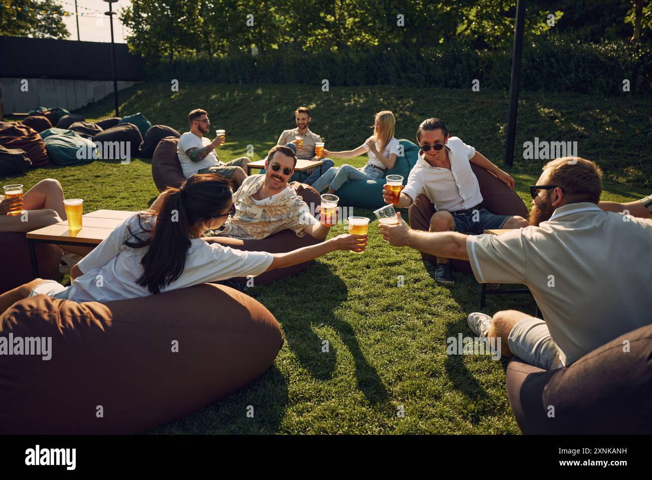 Relaxed Harmony. Friends gathering on public picnic, sitting on ...