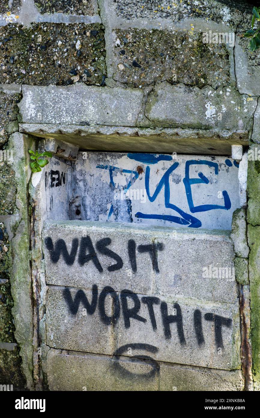 Graffiti sprayed on an old wall in Newquay town centre in Cornwall in ...