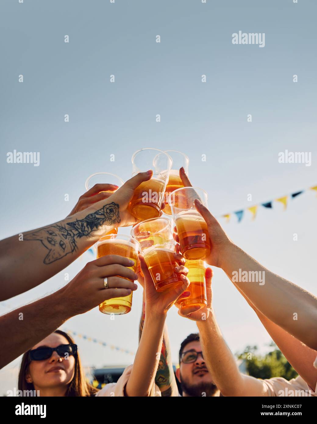 Group of people, friends gathering on picnic, raising glasses with beer ...