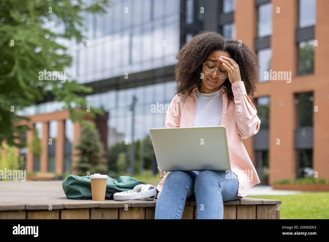 Stressed african american woman student working on laptop on campus ...