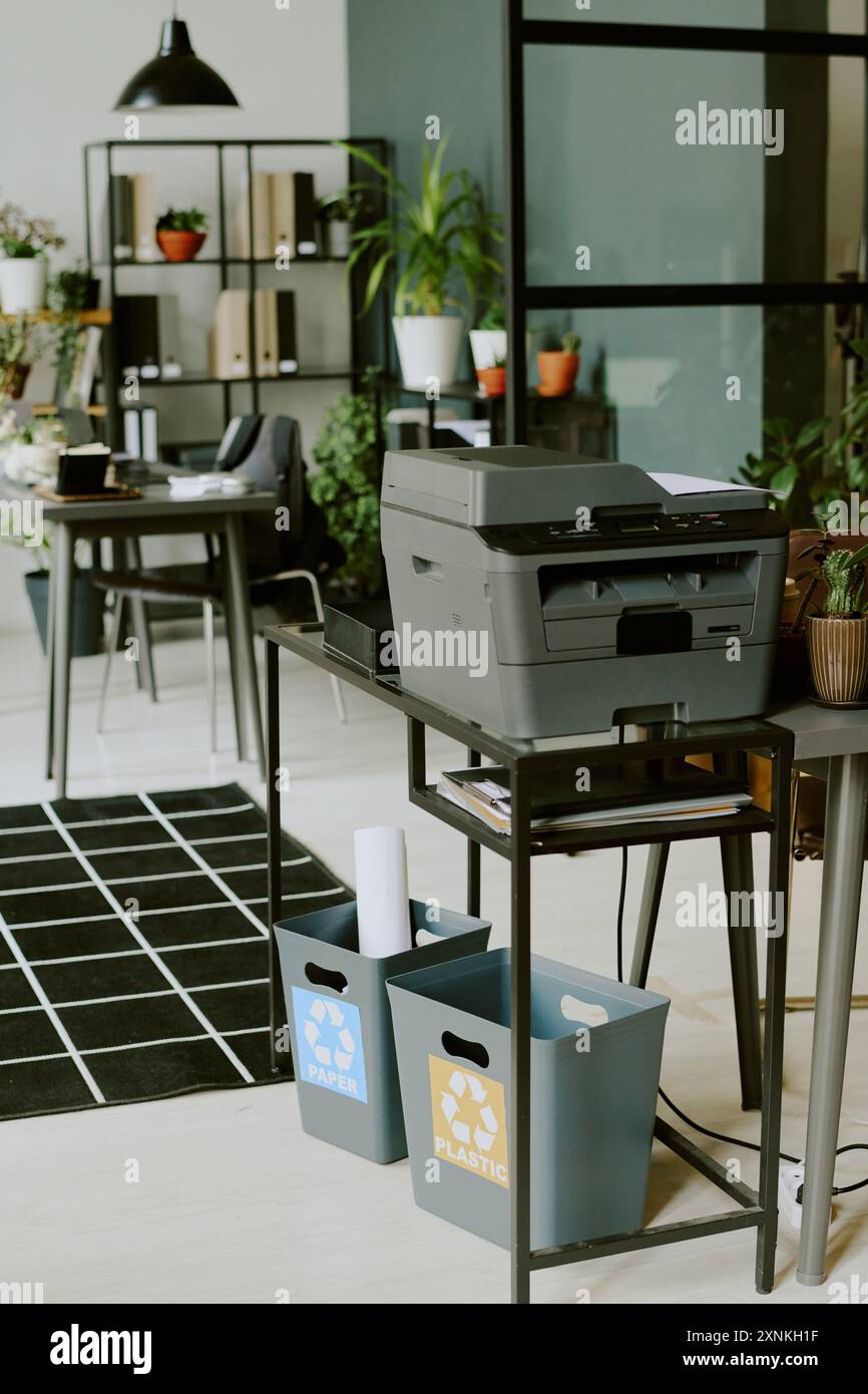 Vertical no people shot of printer on table and recycling bins on floor ...