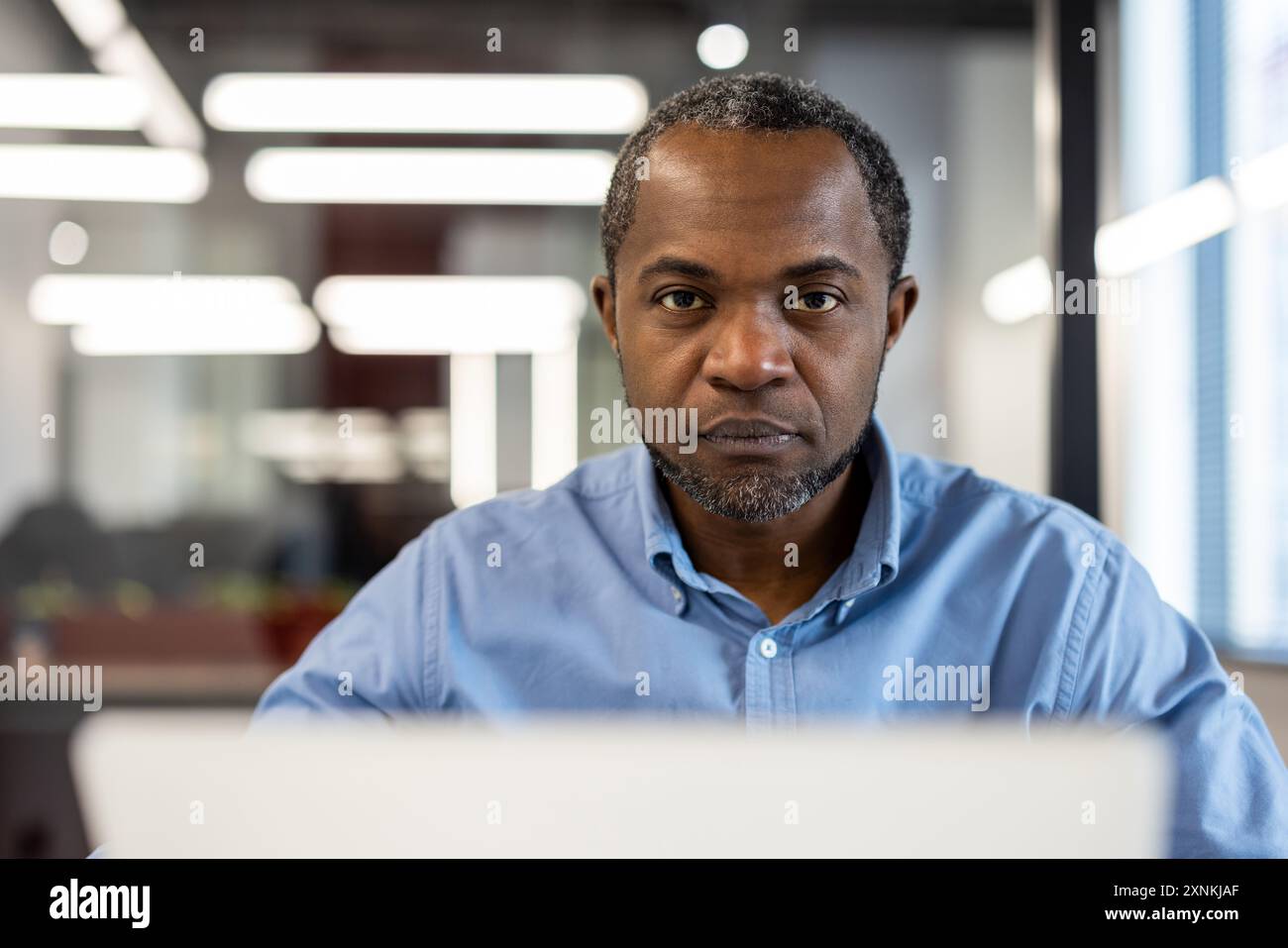 Mature african american office worker looking focused while working at ...