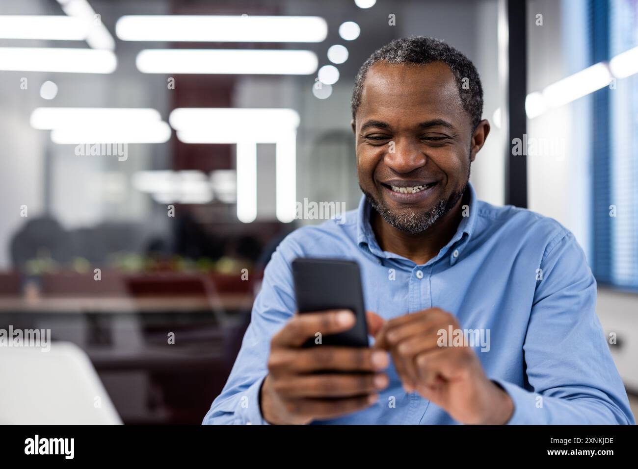 Mature african american businessman sitting in modern office using ...